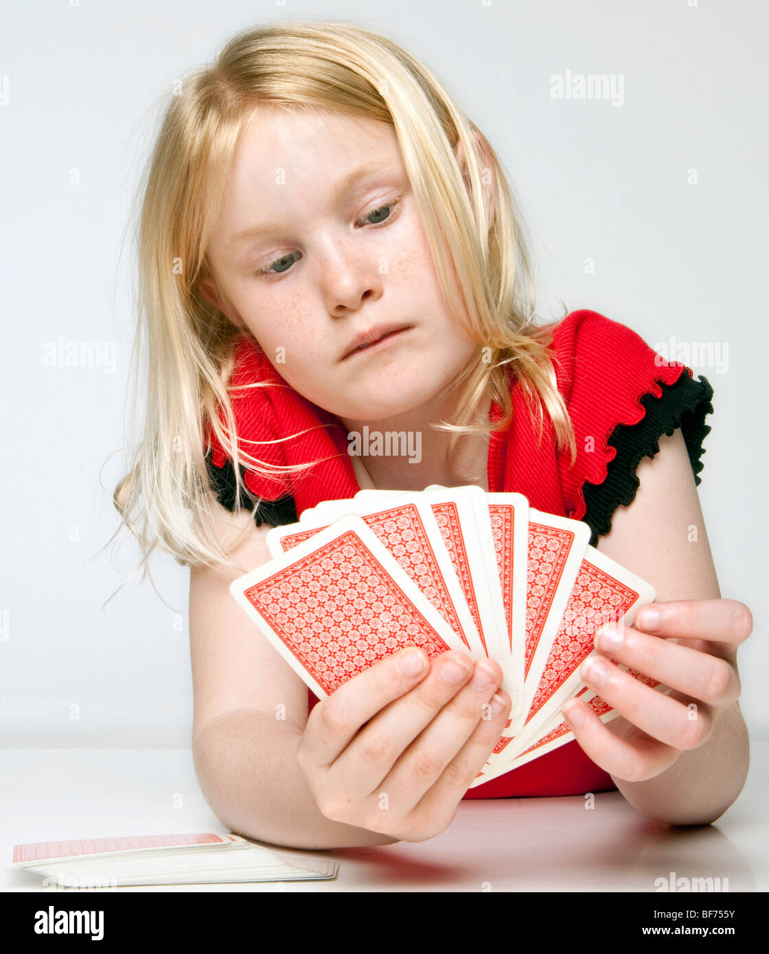 Young pretty caucasian girl holding a hand of playing cards Stock Photo ...
