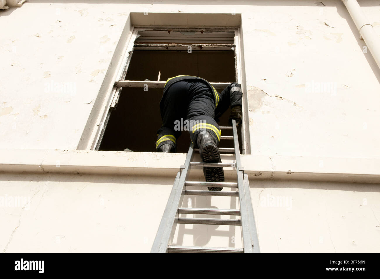 Fireman entering bedroom window from top of ladder Stock Photo - Alamy