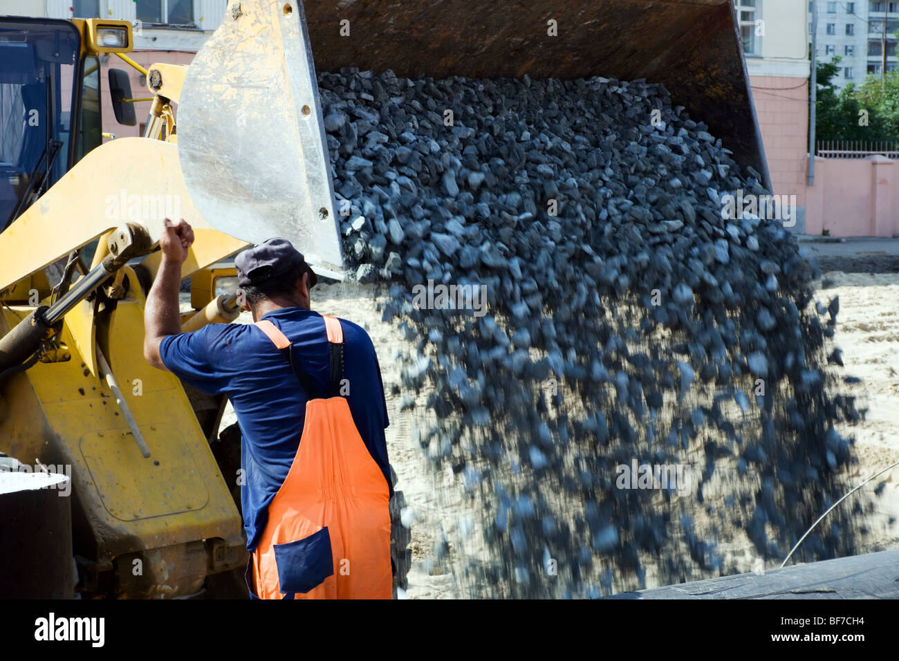 Worker and road loader on the construction of road Stock Photo - Alamy