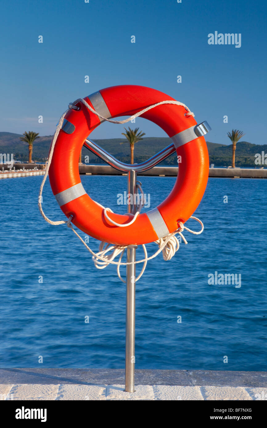 Orange life preserver with a water background Stock Photo - Alamy