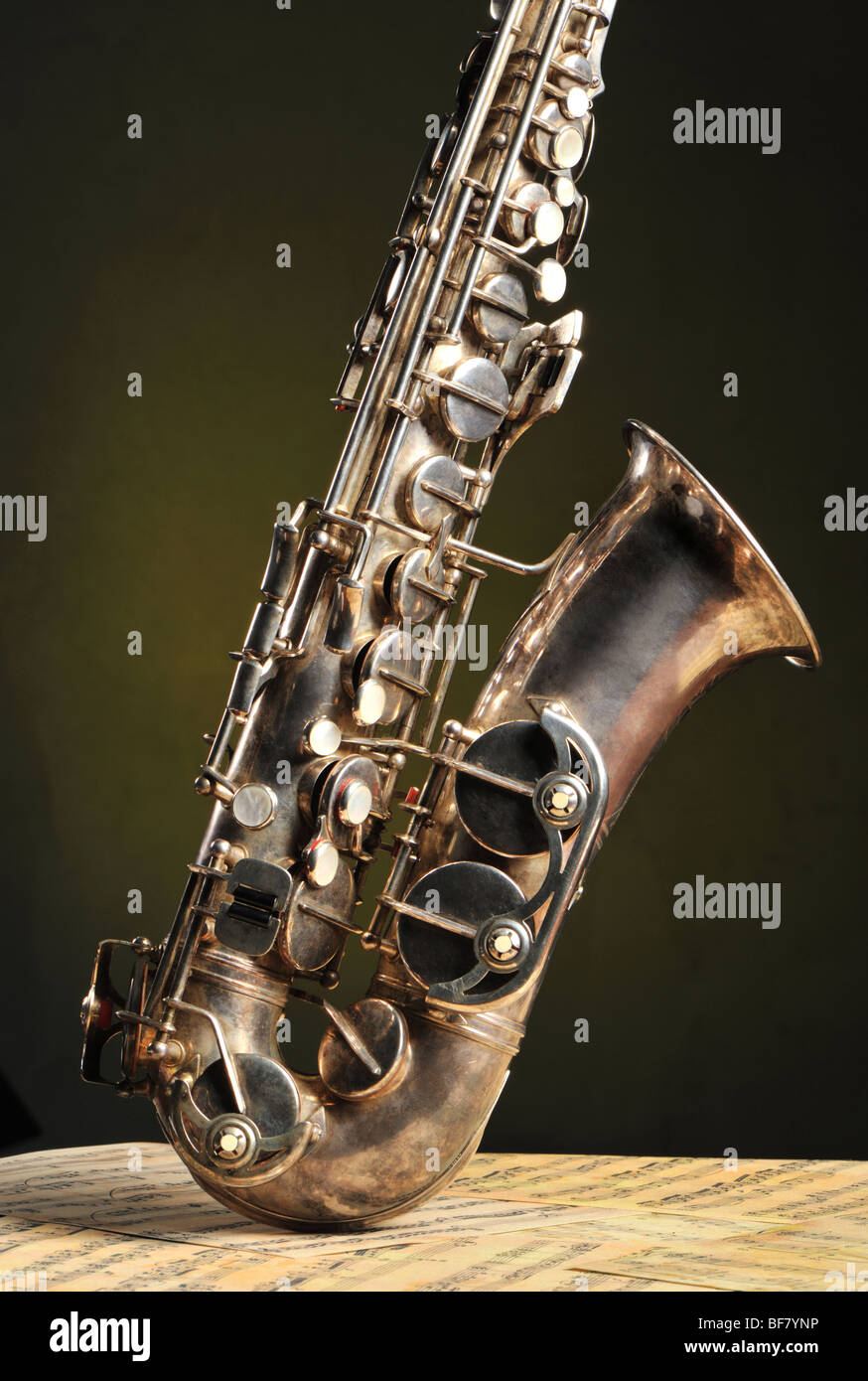 Old saxophone and notes. The Musical instrument standing on notes with ...