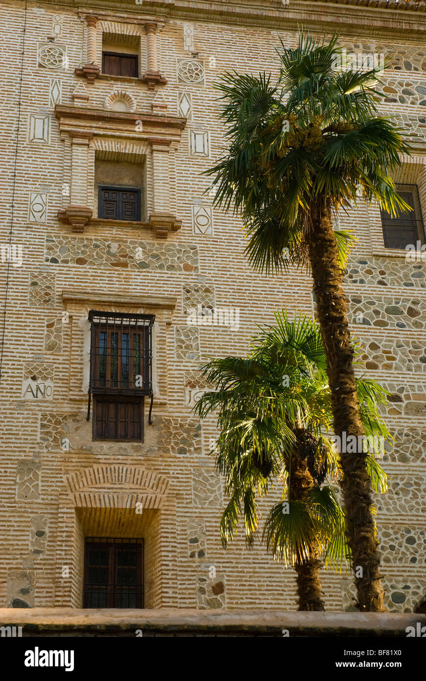 Palm trees growing outside Spanish building Stock Photo - Alamy