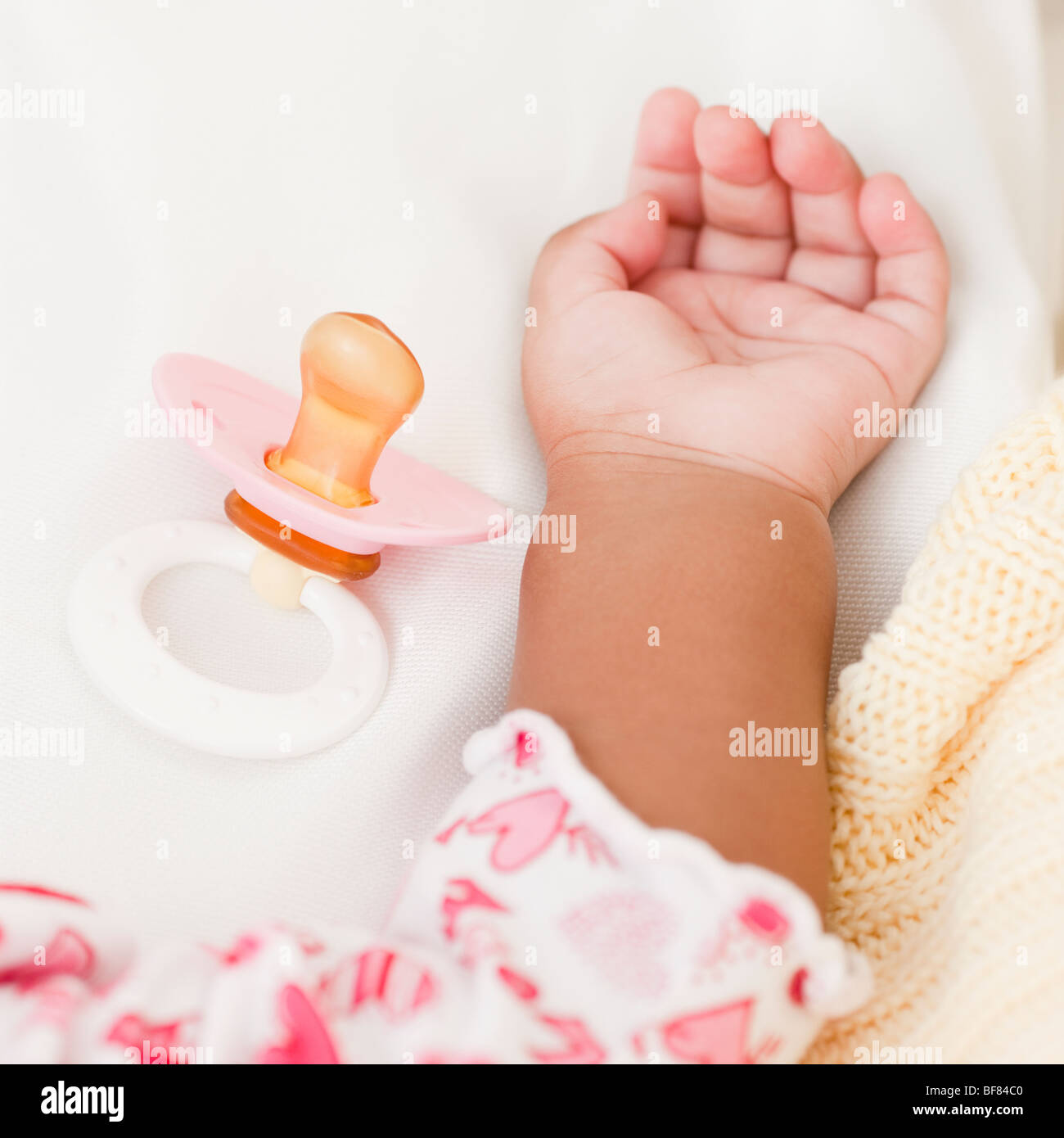 Hand of African baby and pacifier Stock Photo - Alamy