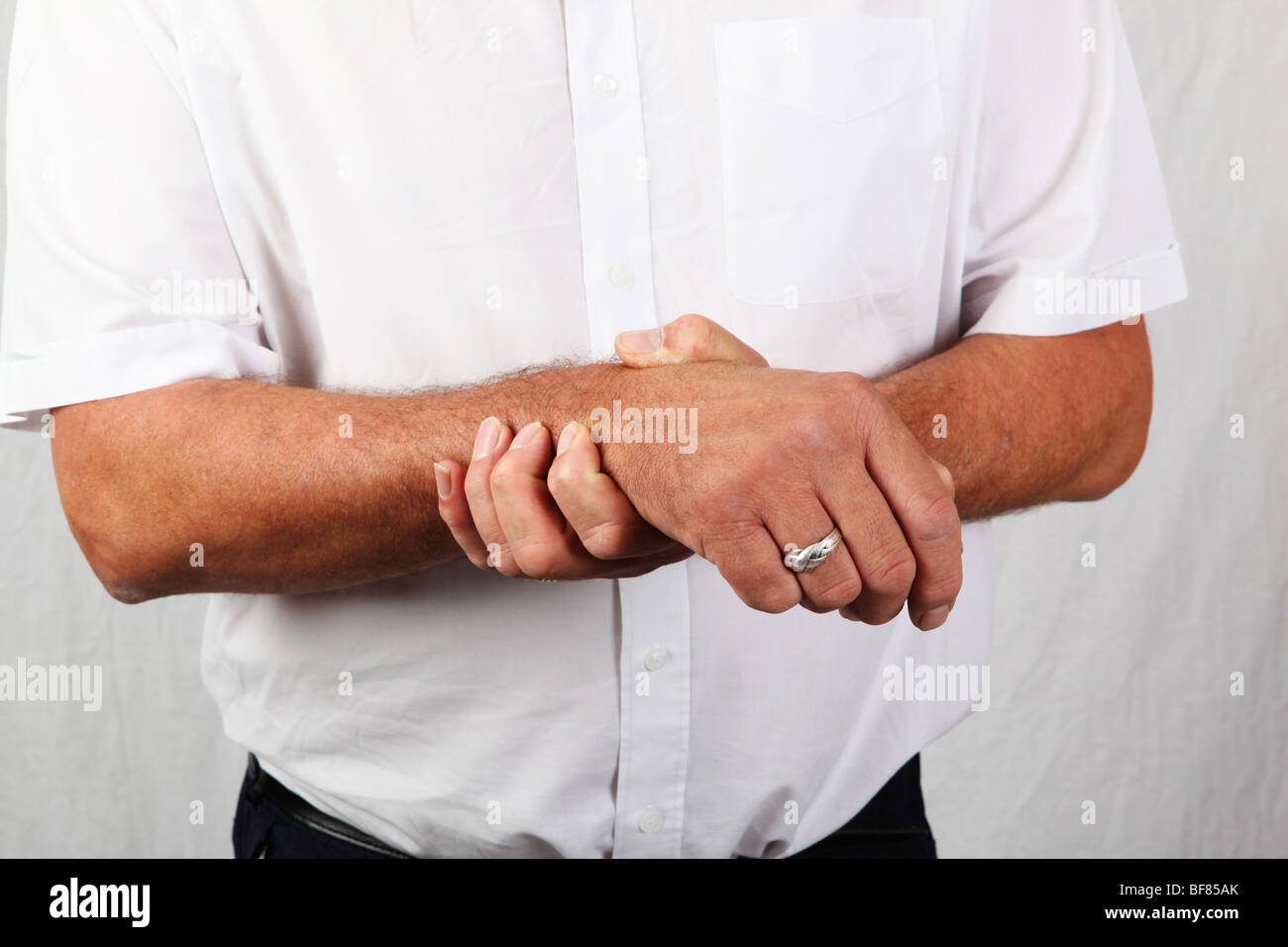 Closeup of late middle aged 60s mature man holds painful wrist joint ...