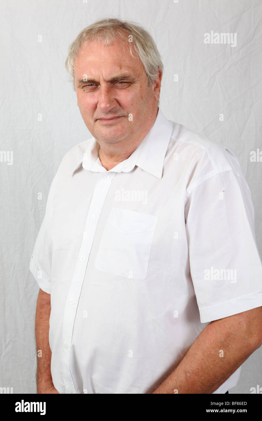 Late middle aged 60s mature man squinting both eyes struggling to see ...