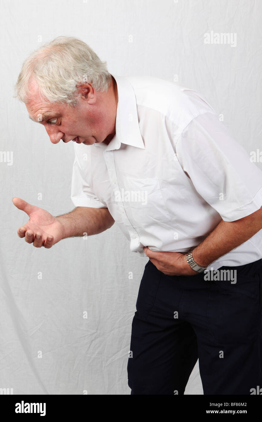 Mid 60s grey haired man holding stomach retching vomiting being sick ...