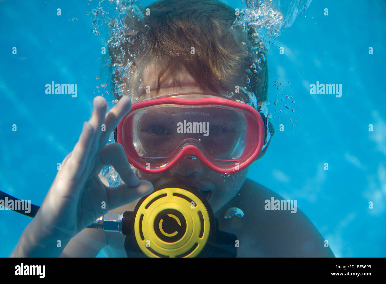 Child with aqua lung underwater giving OK sign Stock Photo - Alamy