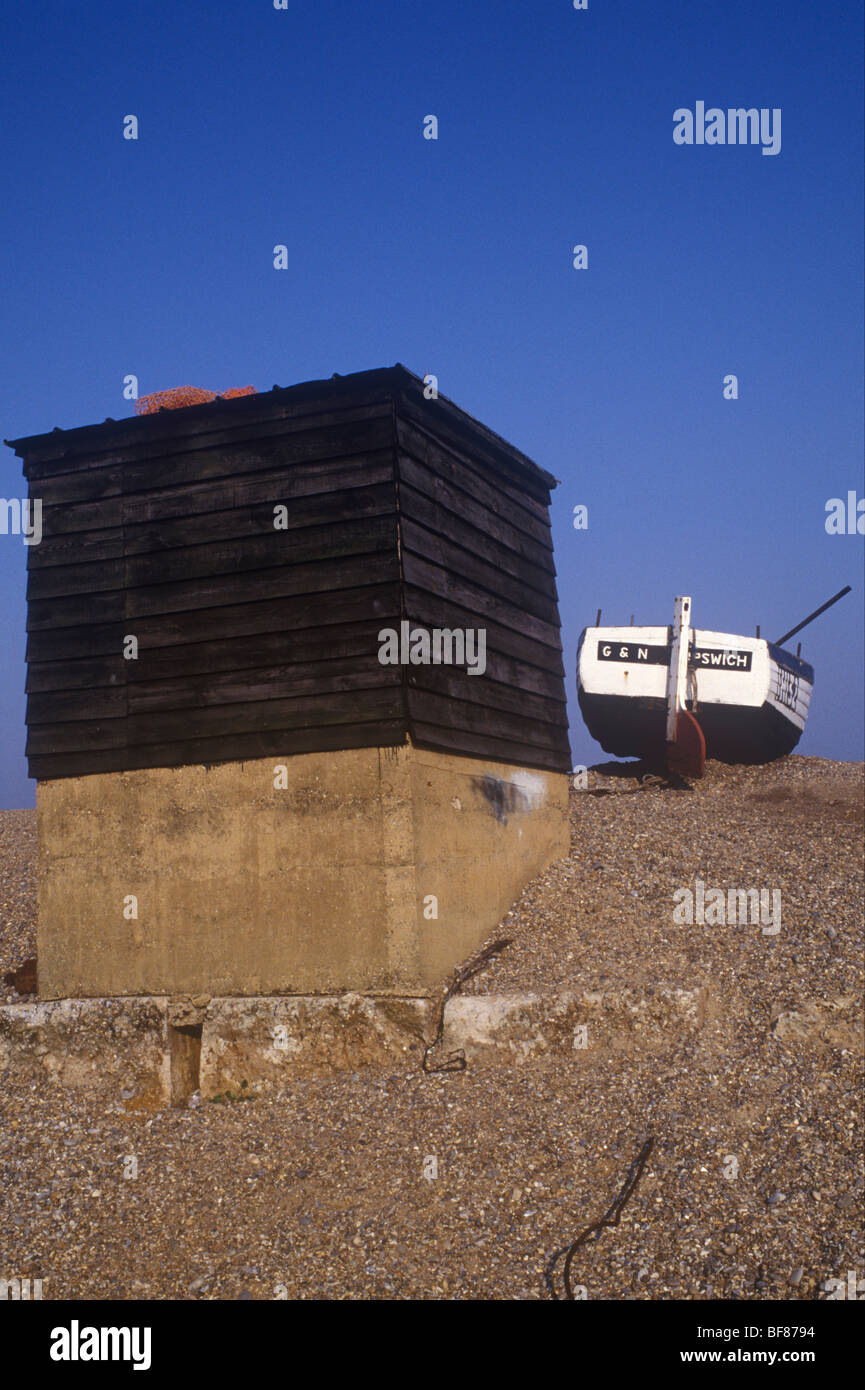 Dunwich Suffolk UK Steep shingle beach with small open fishing boat ...
