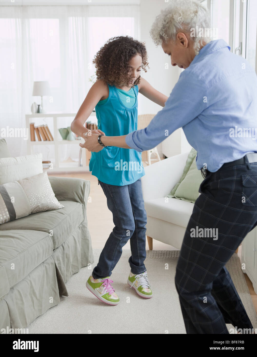 Grandmother and granddaughter dancing in living room Stock Photo - Alamy
