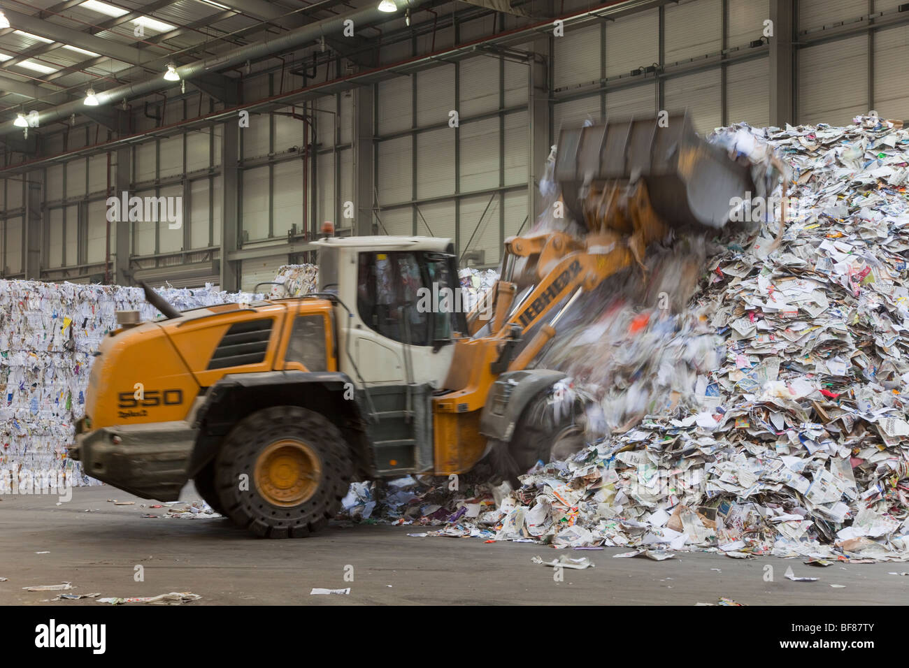Bulldozer moving in paper & plastic recycling factory Stock Photo - Alamy