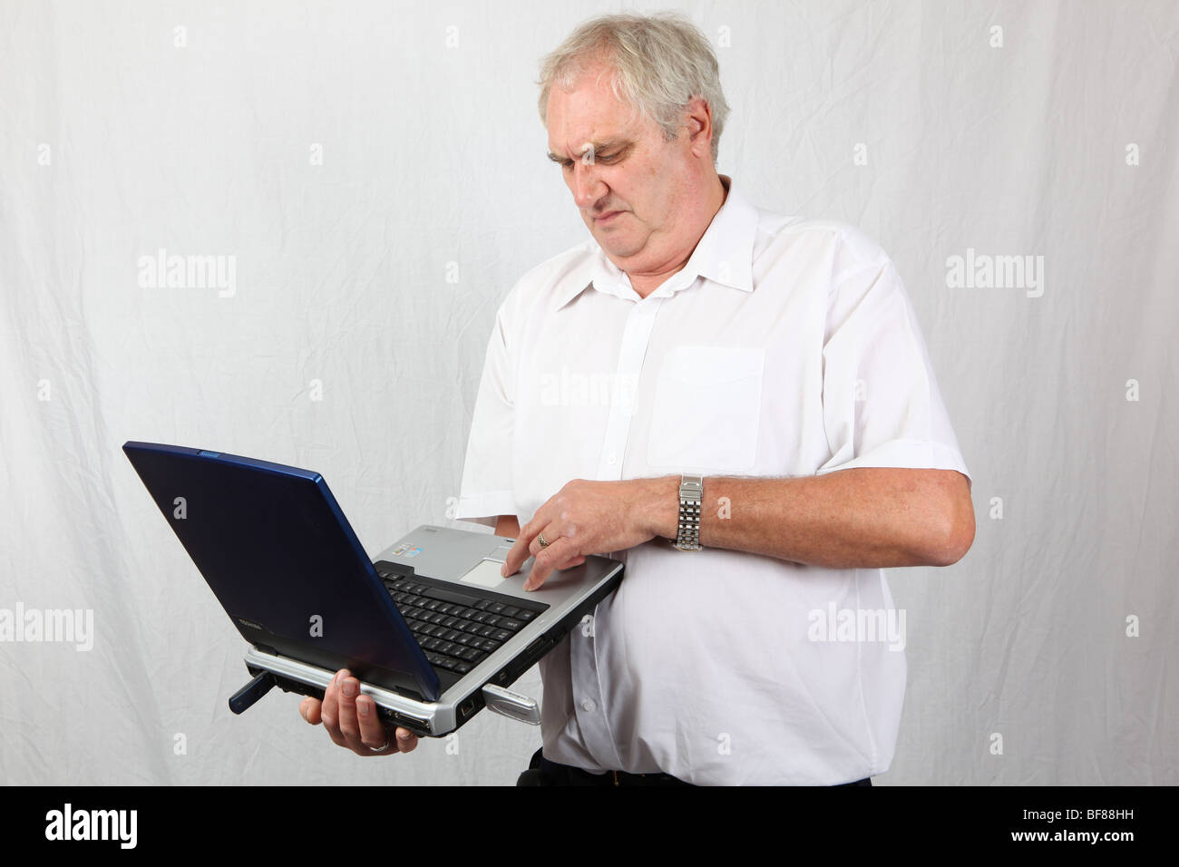 Silver surfer grey haired 60s man looking confused unsure using laptop ...