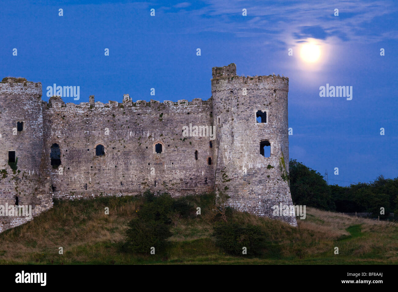 The moon rising behind Carew Castle beside the Carew River at Carew ...