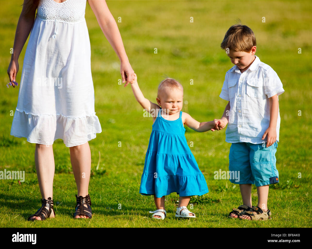 Mother and two kids having fun outdoors at sunny summer day Stock Photo ...