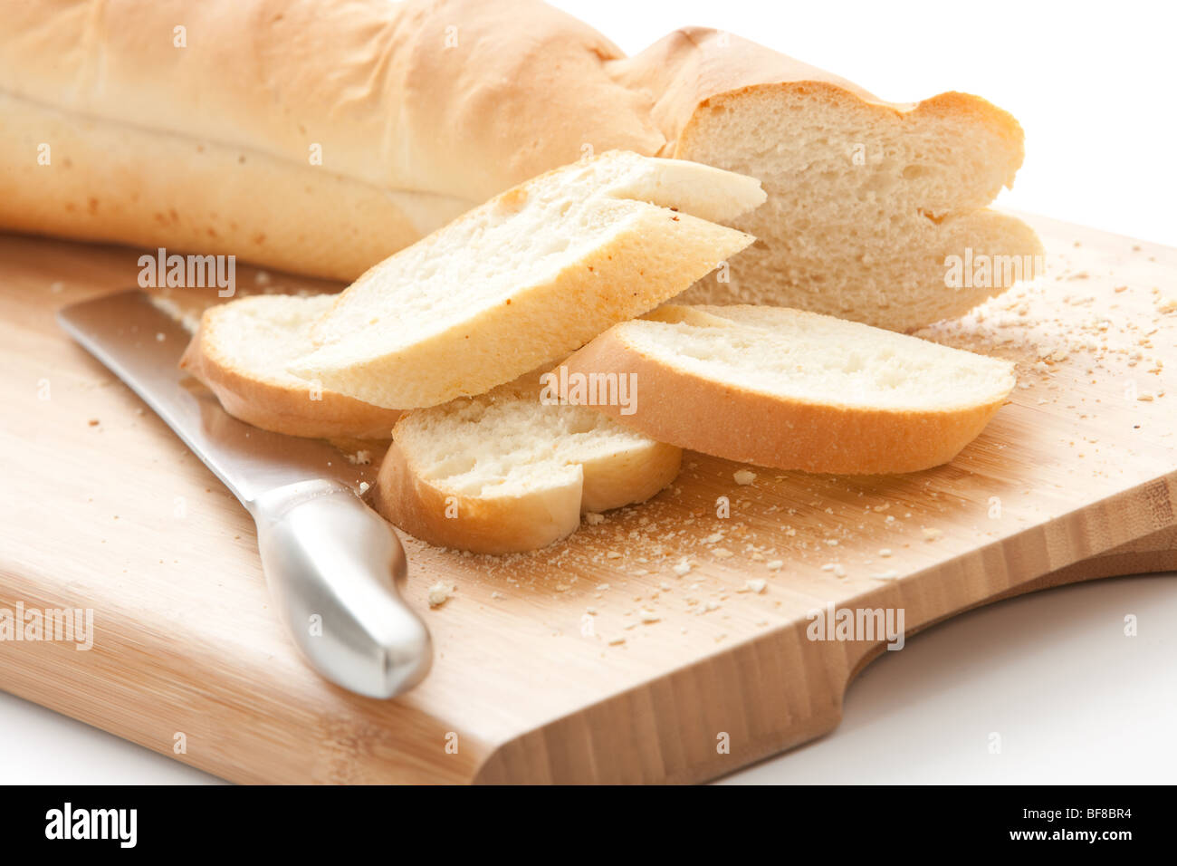 french bread loaf sliced on cutting board on white background Stock ...