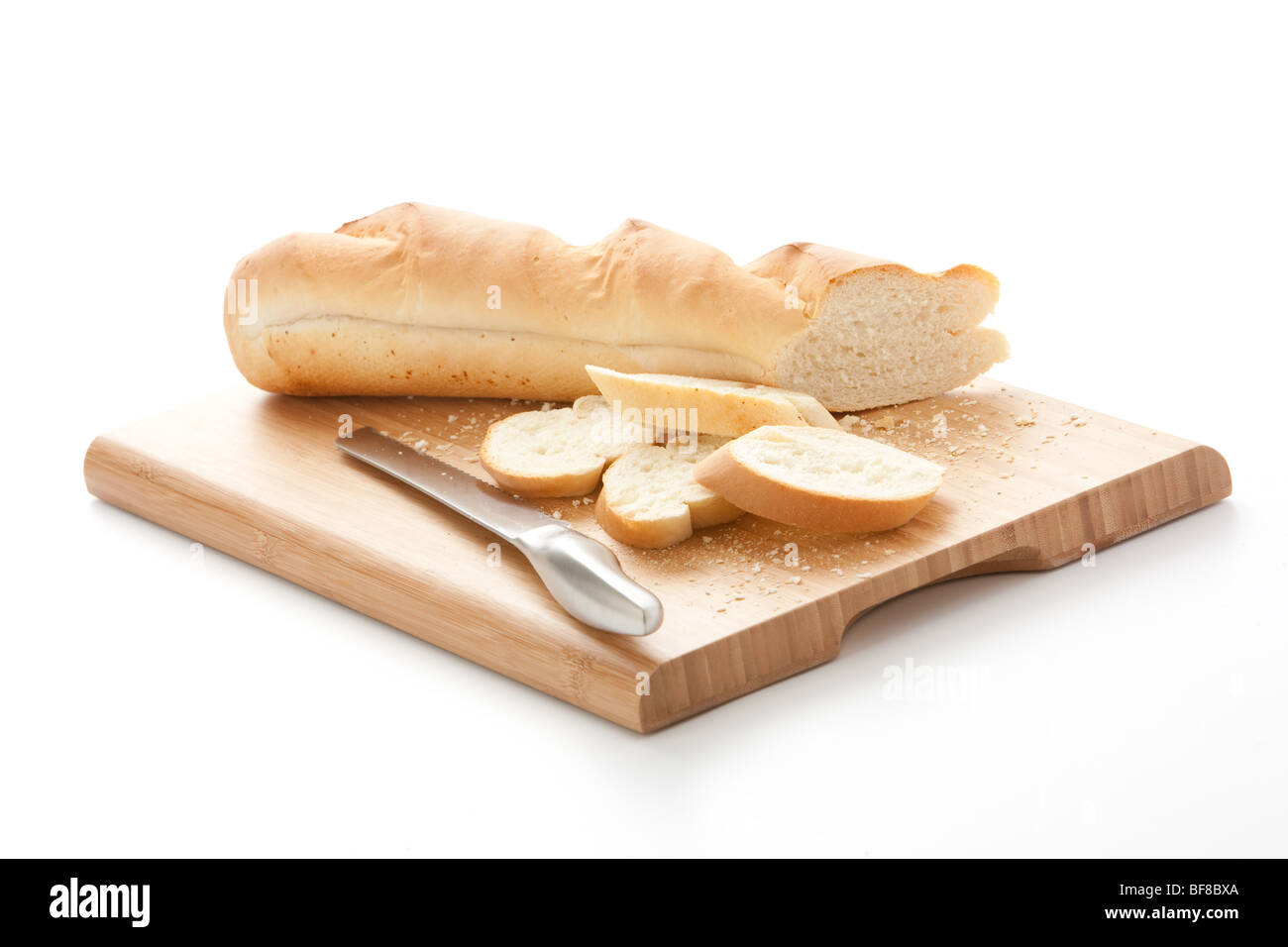 french bread loaf sliced on cutting board on white background Stock ...
