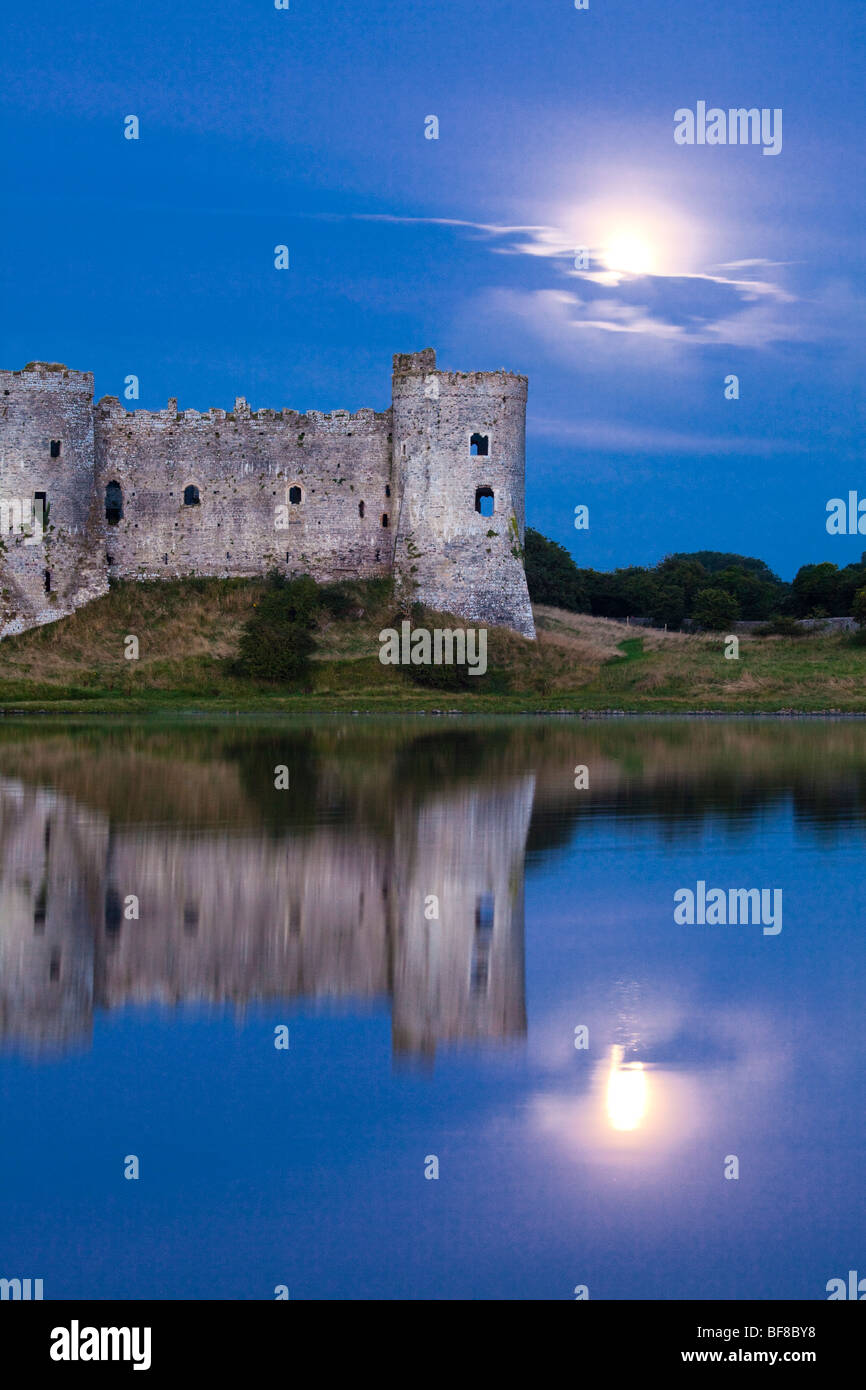 The moon rising behind Carew Castle beside the Carew River at Carew ...
