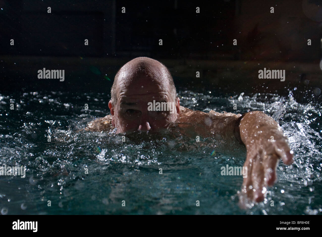 Man swimming in a swimming pool at night Stock Photo - Alamy