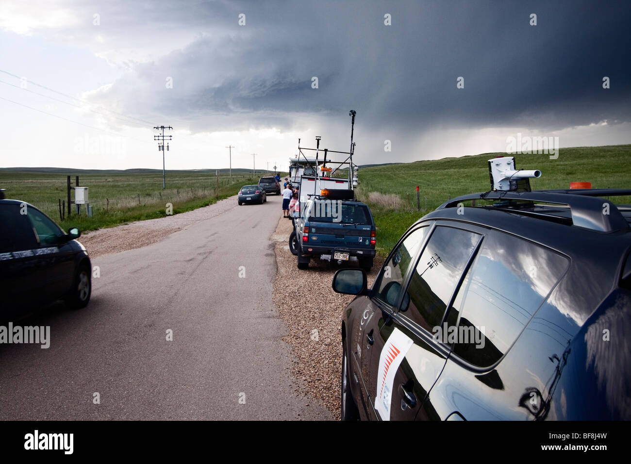 Storm chasers participating in Project Vortex 2 park along a road in ...