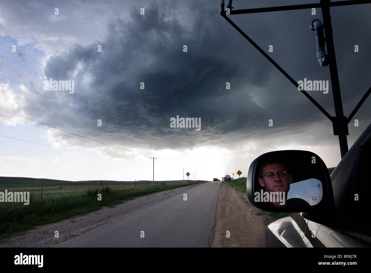 A scientist participating in Project Vortex 2 park along a road to ...