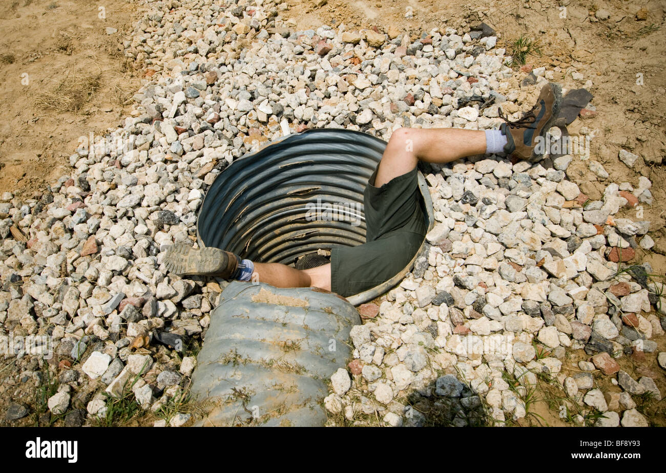 man falling into drain pipe Stock Photo - Alamy