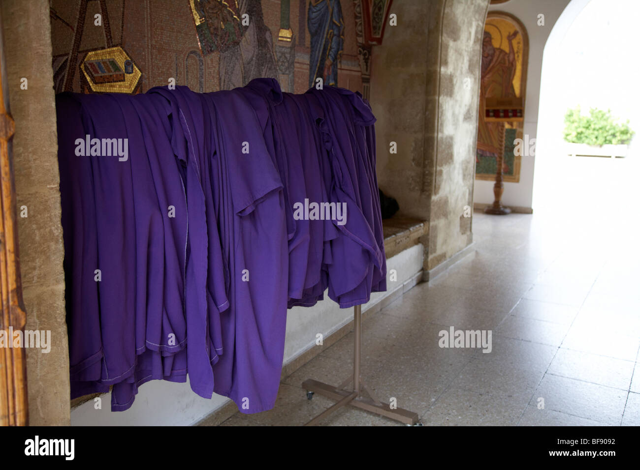 purple robes for visitors to cover up at the entrance of the Holy Royal ...