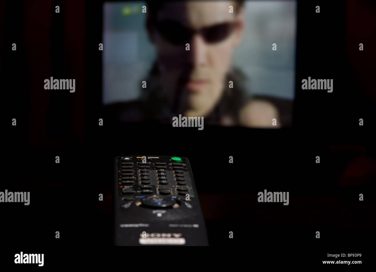 Remote control with TV in background Stock Photo - Alamy