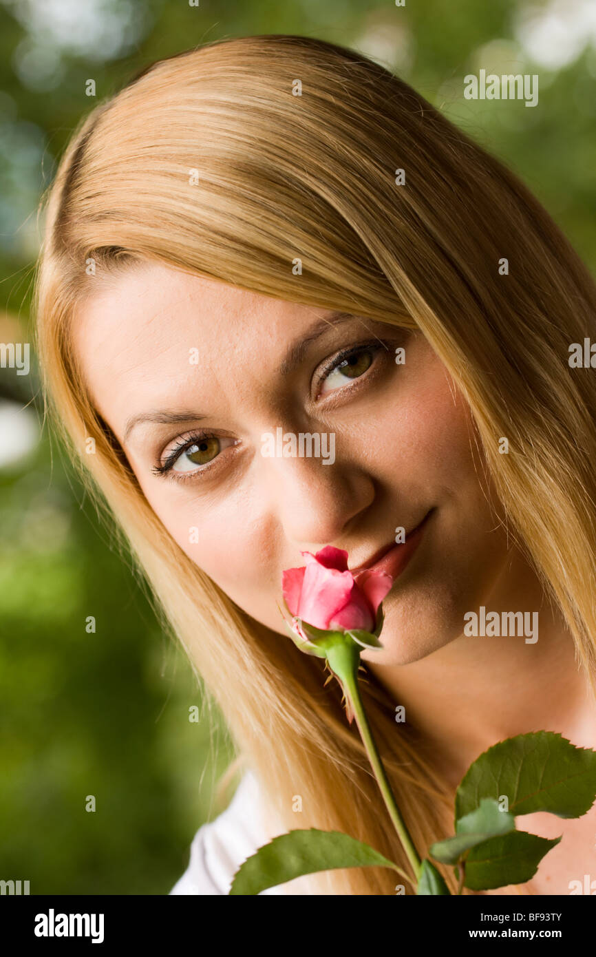 Young woman holding pink rose Stock Photo - Alamy