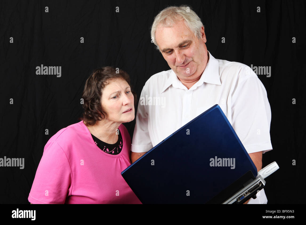 Married couple using wireless laptop silver surfers husband showing ...