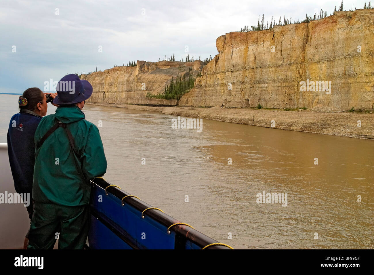 Man and woman look at The Ramparts, 100-200 foot tall wall of limestone ...