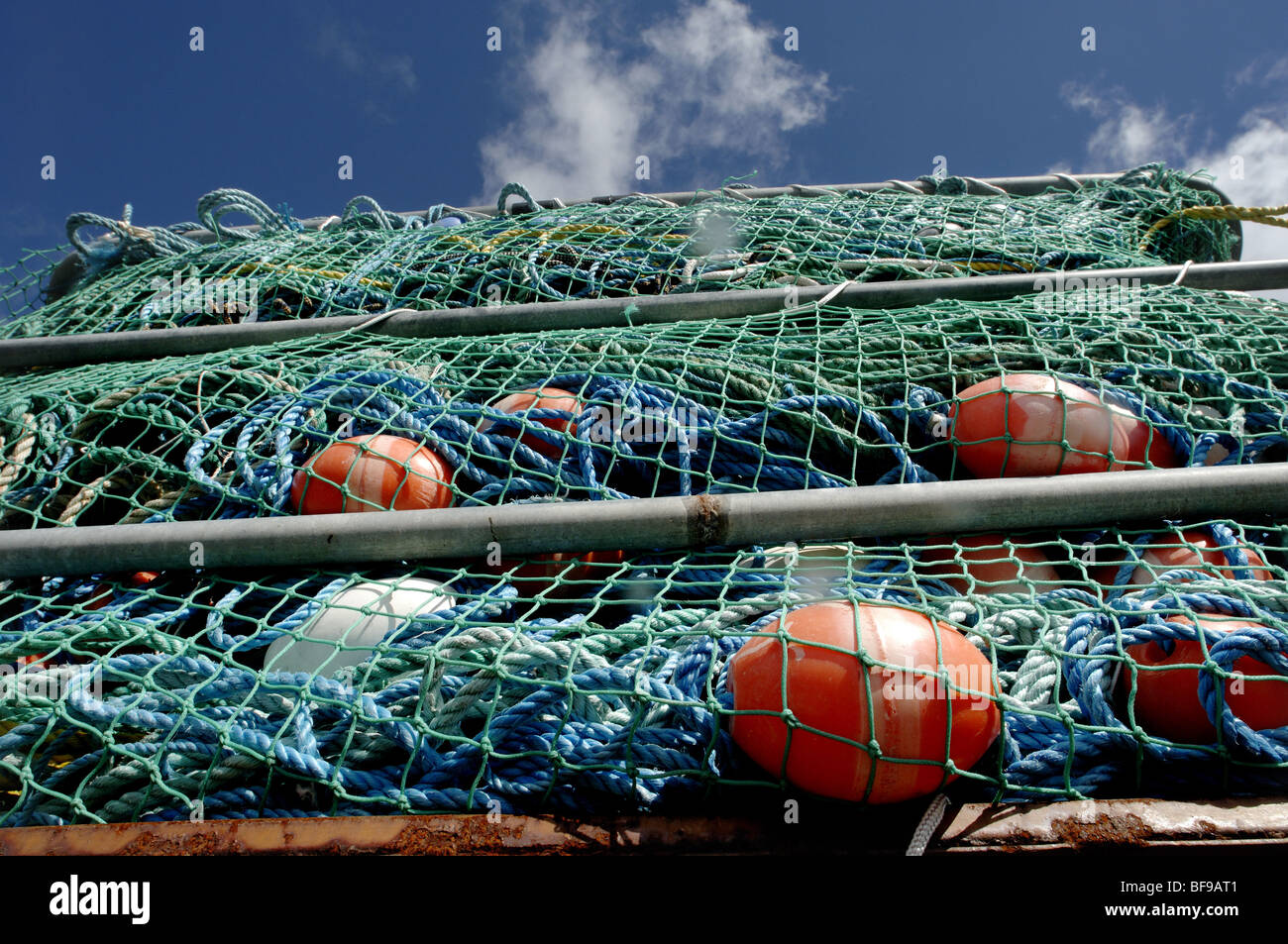 colourful commercial fishing nets piled up on a rusty trailer in Dingle ...