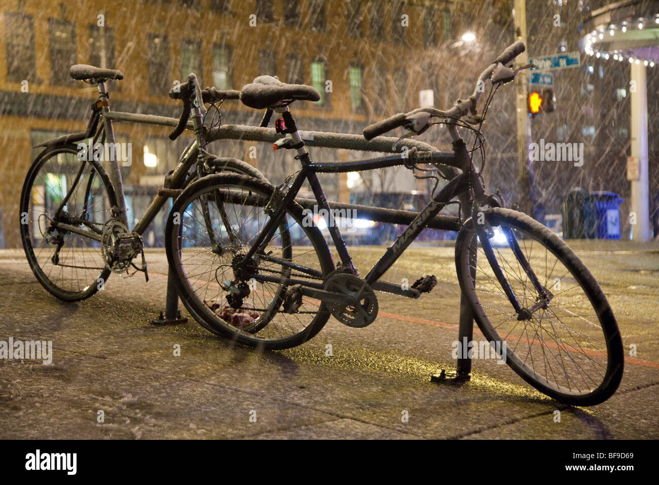 Bicycles secured to bike rack on sidewalk during snow storm, Seattle ...