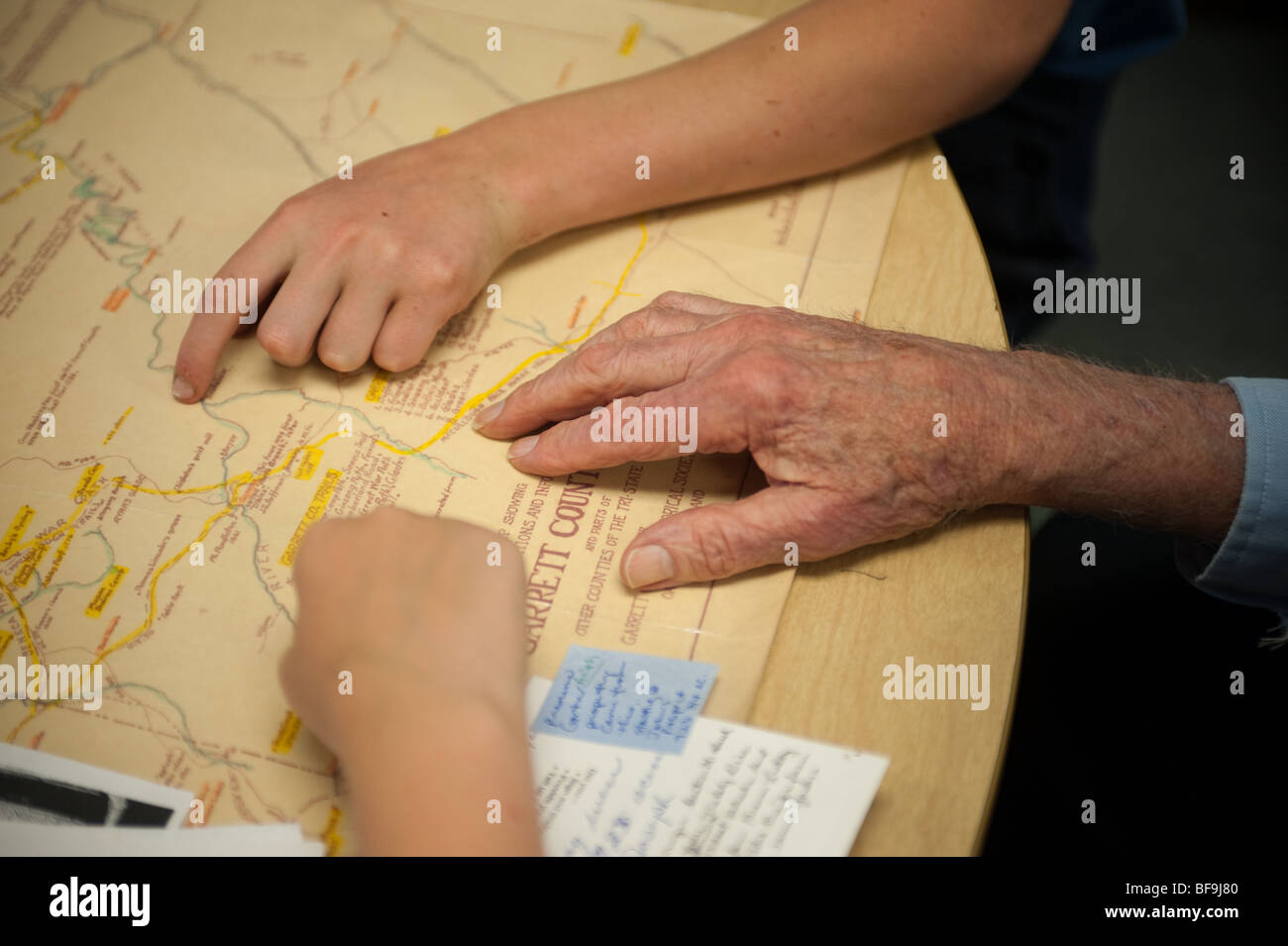 Children and senior hands on old map Stock Photo - Alamy