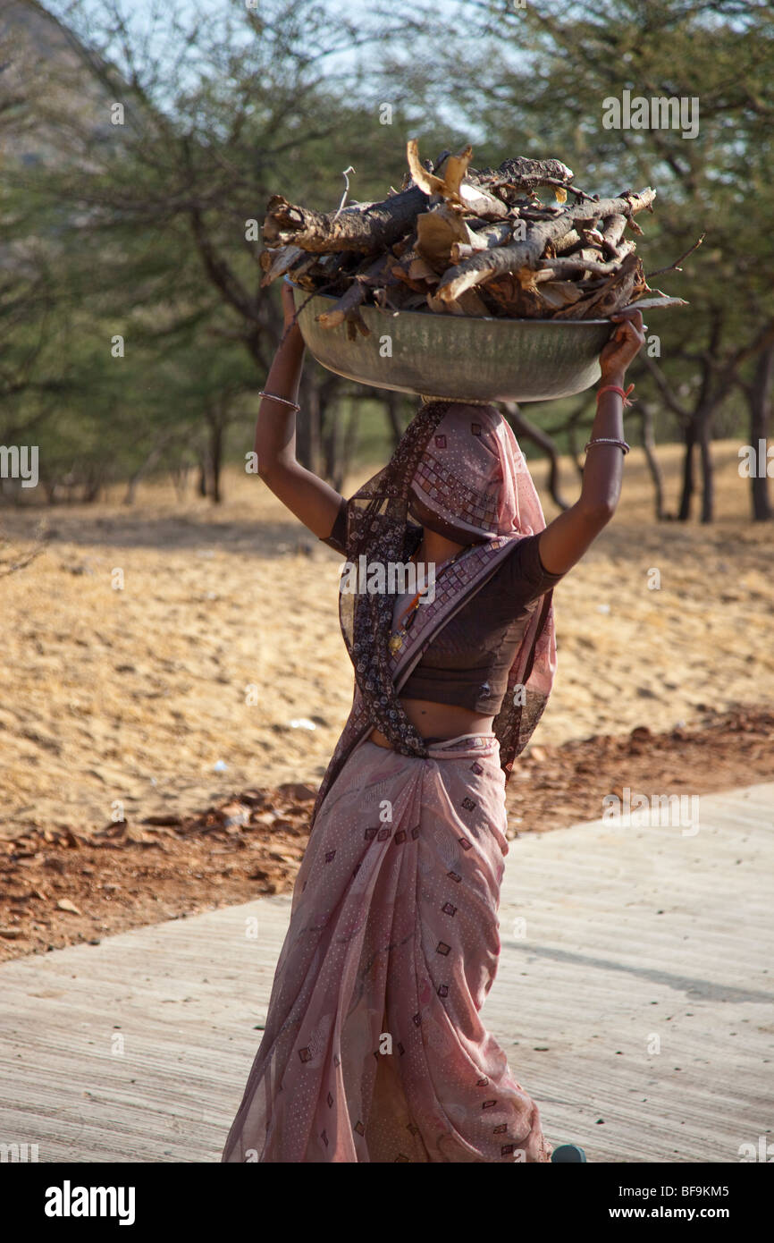 Woman balancing firewood on her head hi-res stock photography and ...