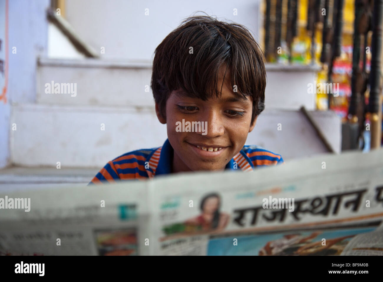 Indian boy reading a newspaper in Pushkar in Rajasthan India Stock ...