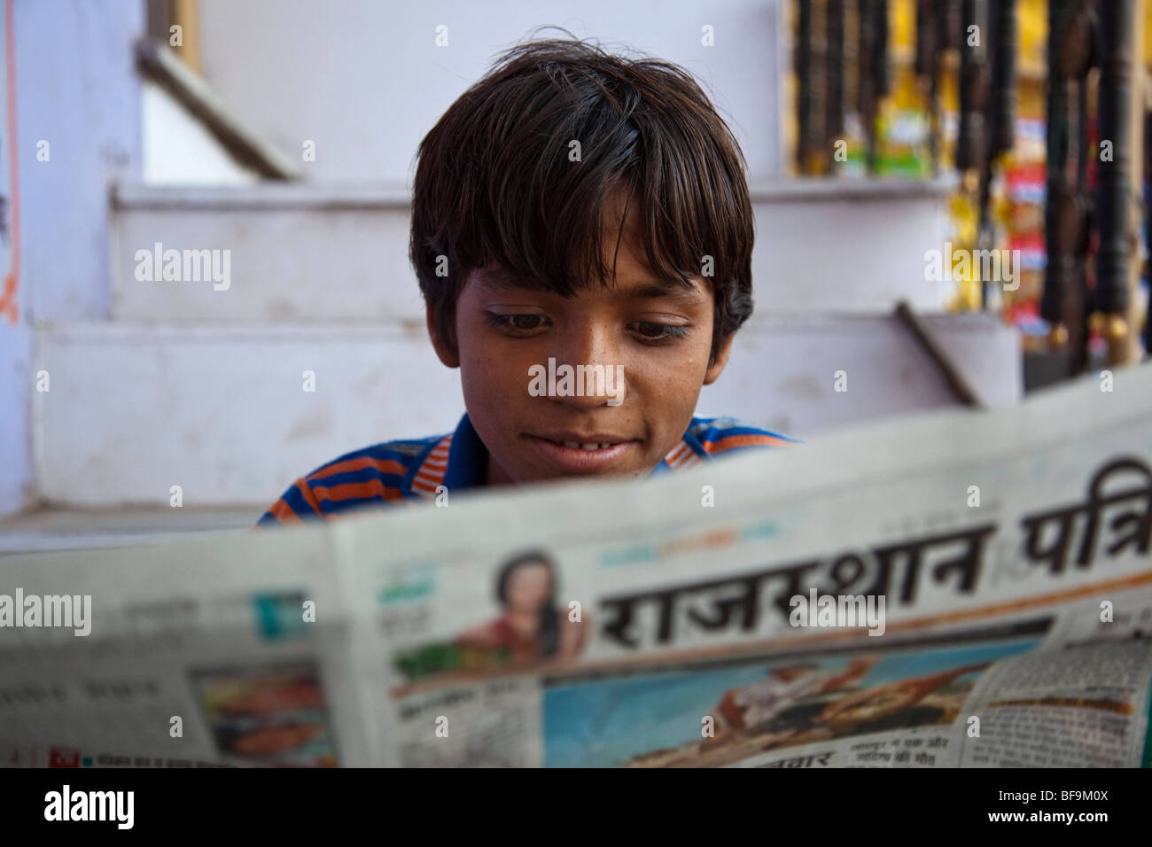 Indian boy reading a newspaper in Pushkar in Rajasthan India Stock ...