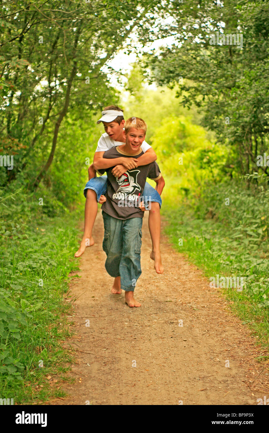 young boy carrying his friend on his shoulders Stock Photo - Alamy