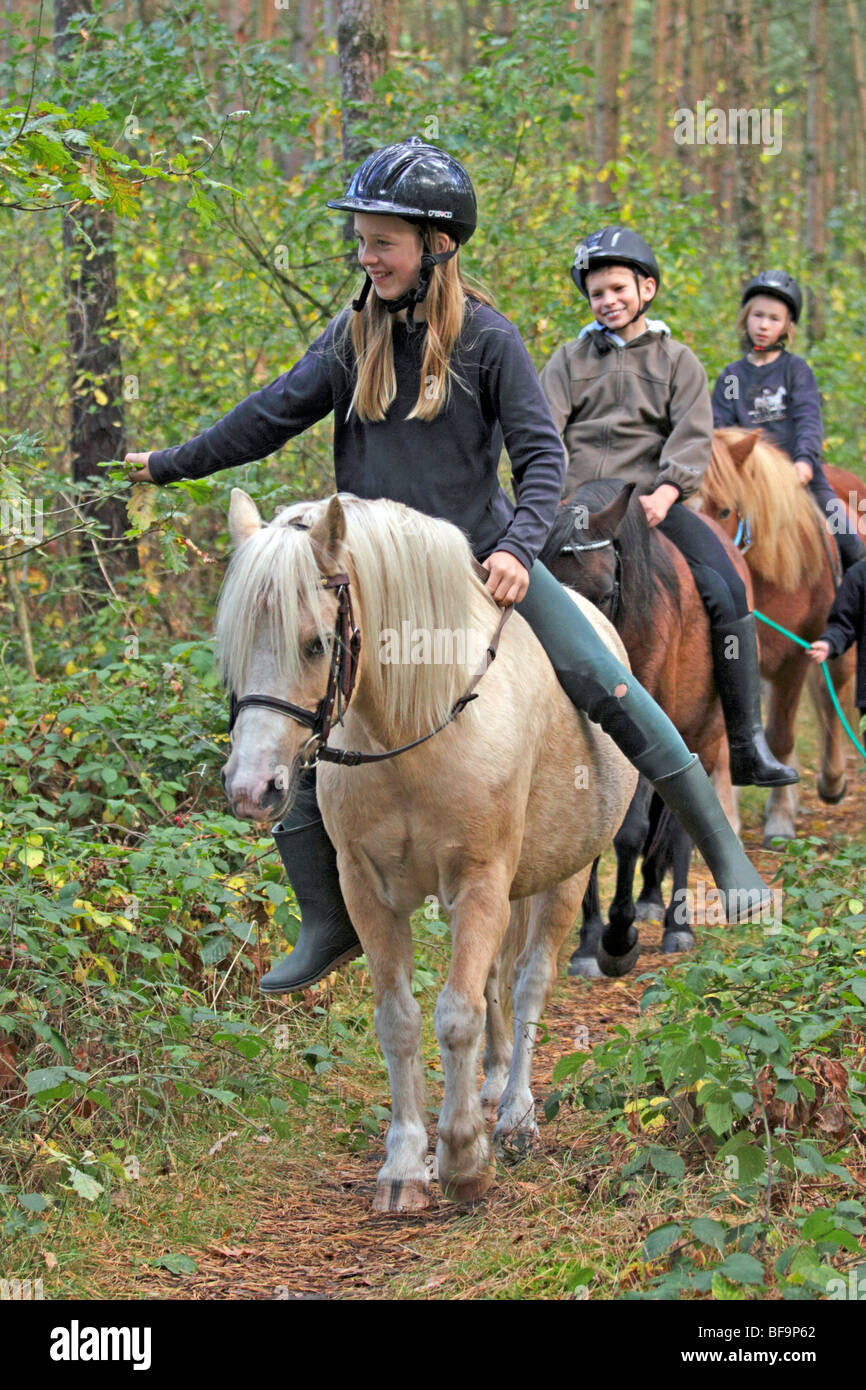 children horseback riding in a forest Stock Photo - Alamy