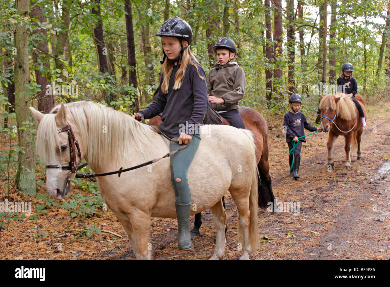 children horseback riding in a forest Stock Photo - Alamy