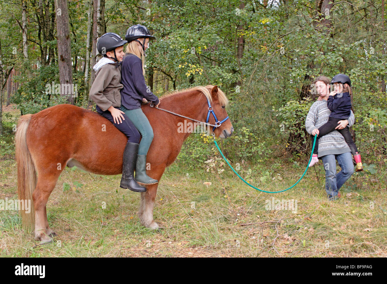 children horseback riding in a forest Stock Photo - Alamy