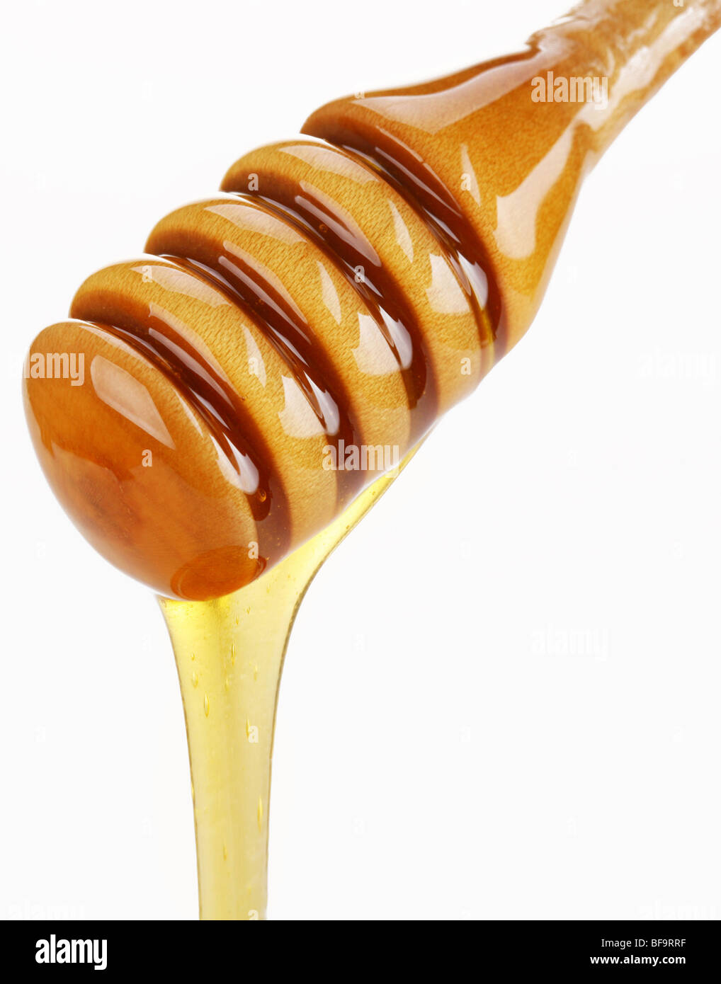Wooden honey drizzler isolated on a white background Stock Photo - Alamy