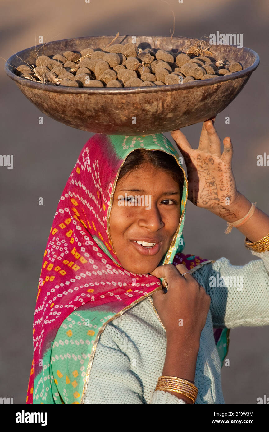 Girl carrying camel dung for biofuel at the Camel Fair in Pushkar in ...