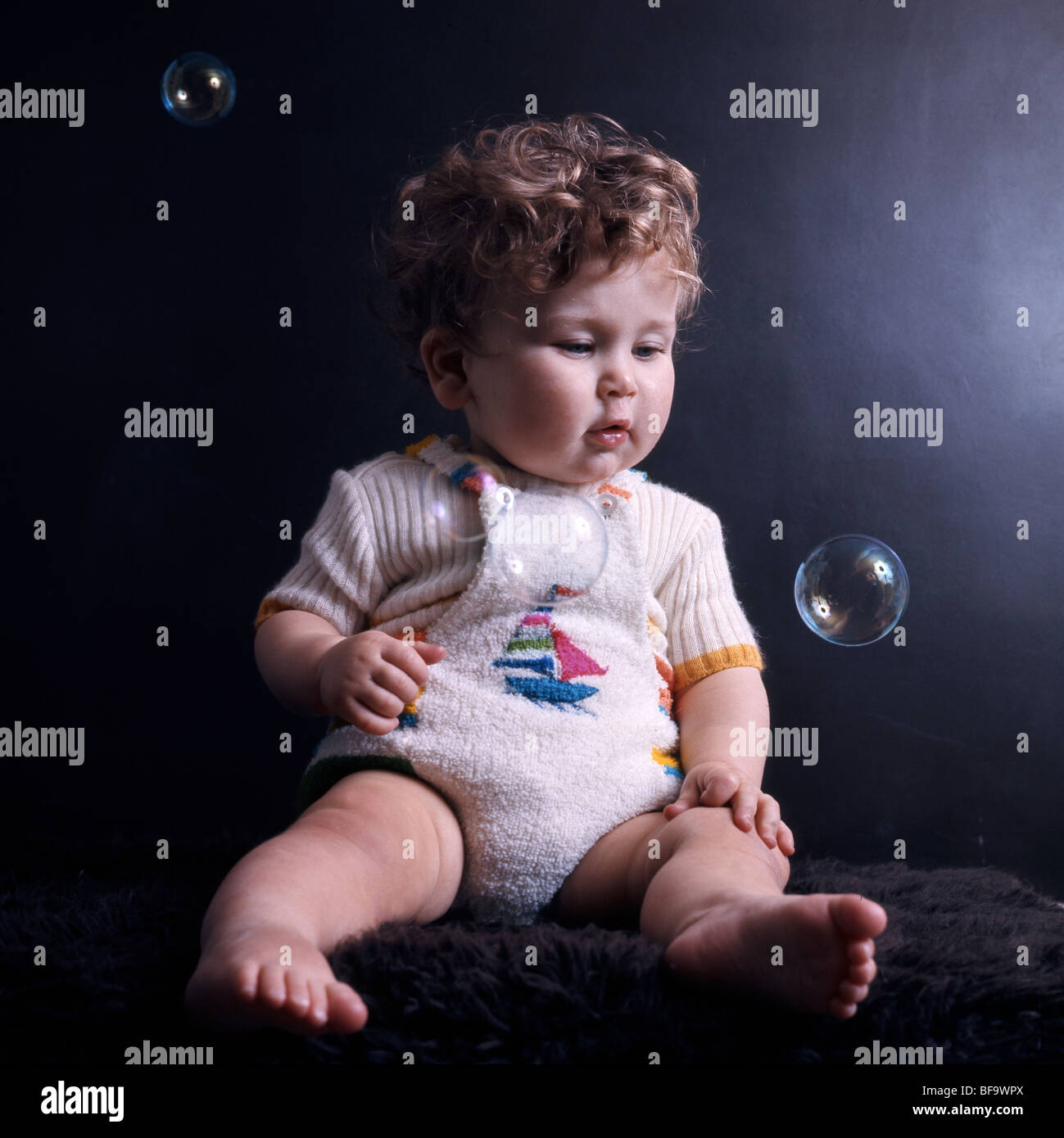 Baby boy fascinated by bubbles Stock Photo - Alamy