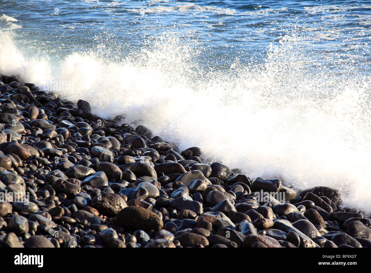 single wave of the Atlantic Ocean at the lava pebble beach of Madeira ...