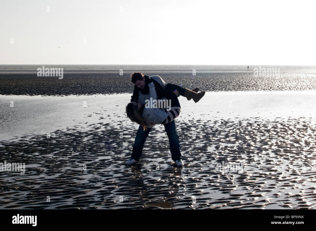 Couple frolicking on beach Stock Photo - Alamy