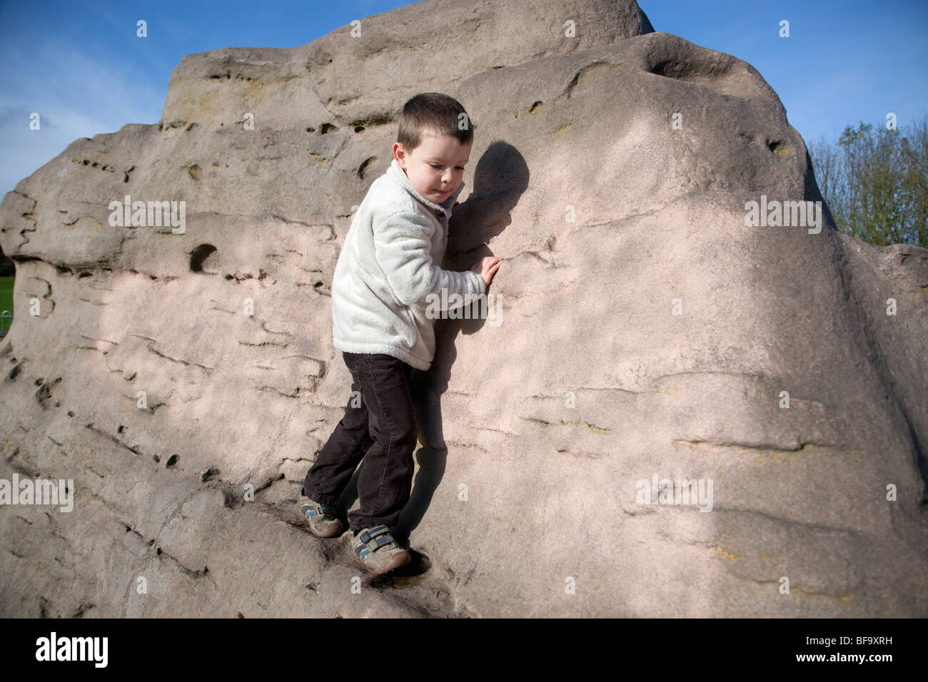 A young boy on a practice climbing rock Stock Photo - Alamy