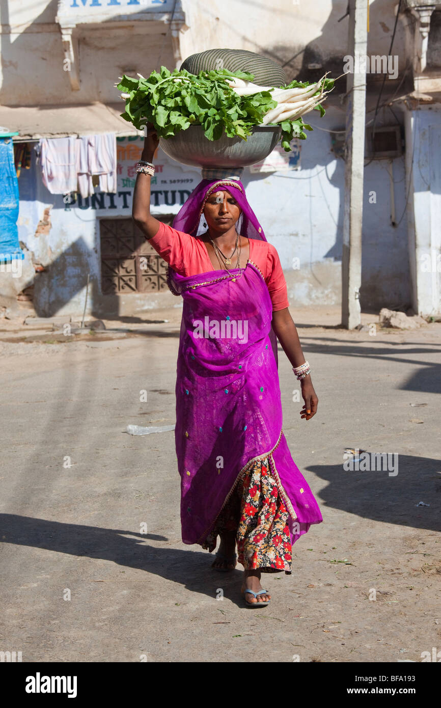 Woman carrying vegetables on her head in Pushkar India Stock Photo - Alamy