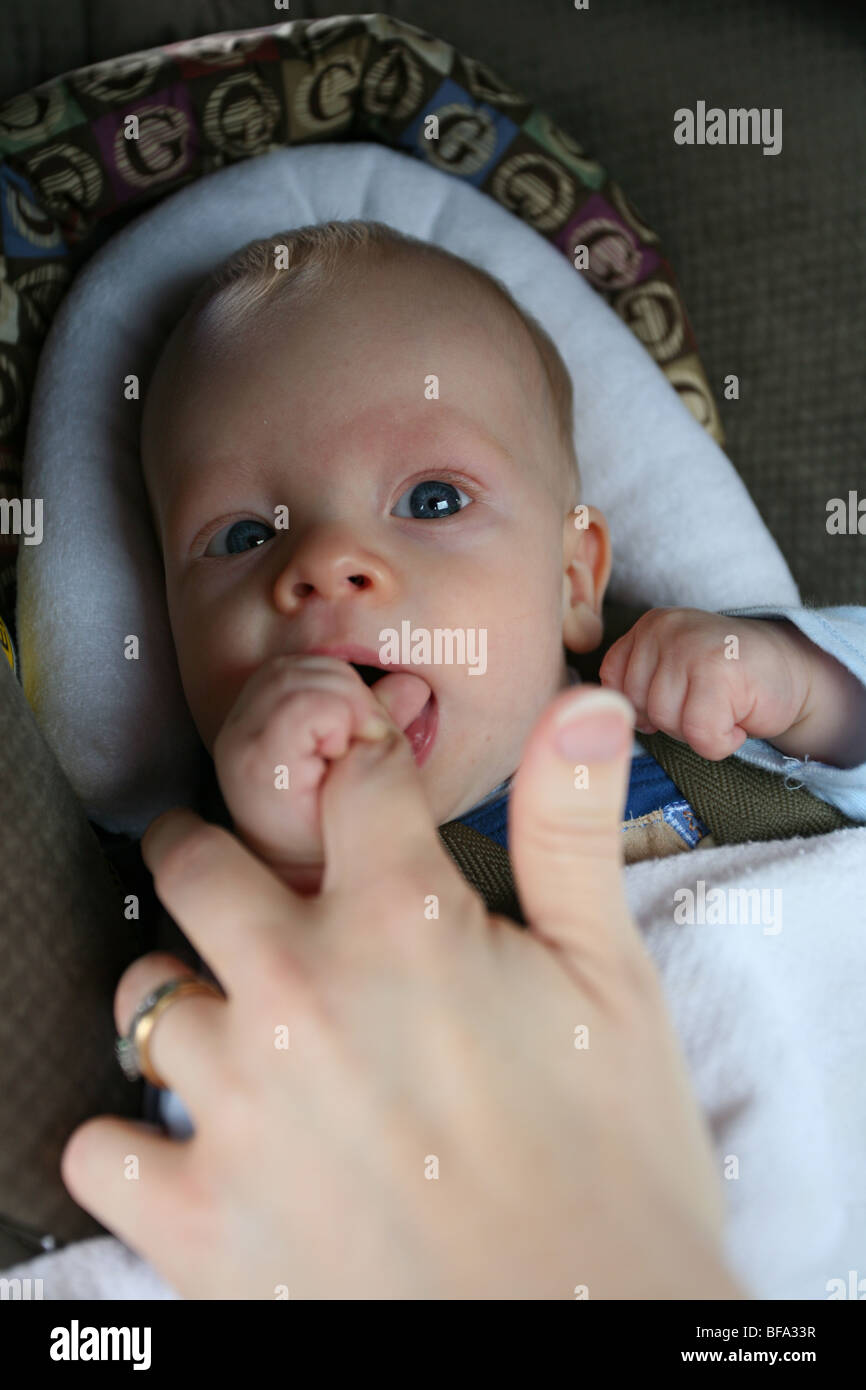 Baby biting his mother's finger Stock Photo - Alamy
