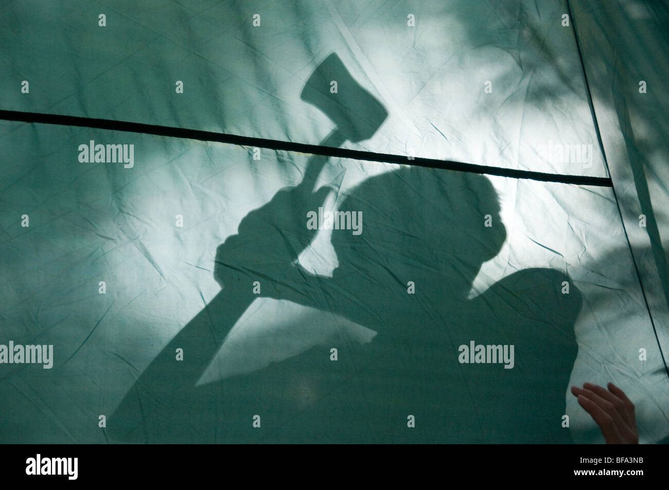 Shadow of person with hatchet on tent wall Stock Photo - Alamy