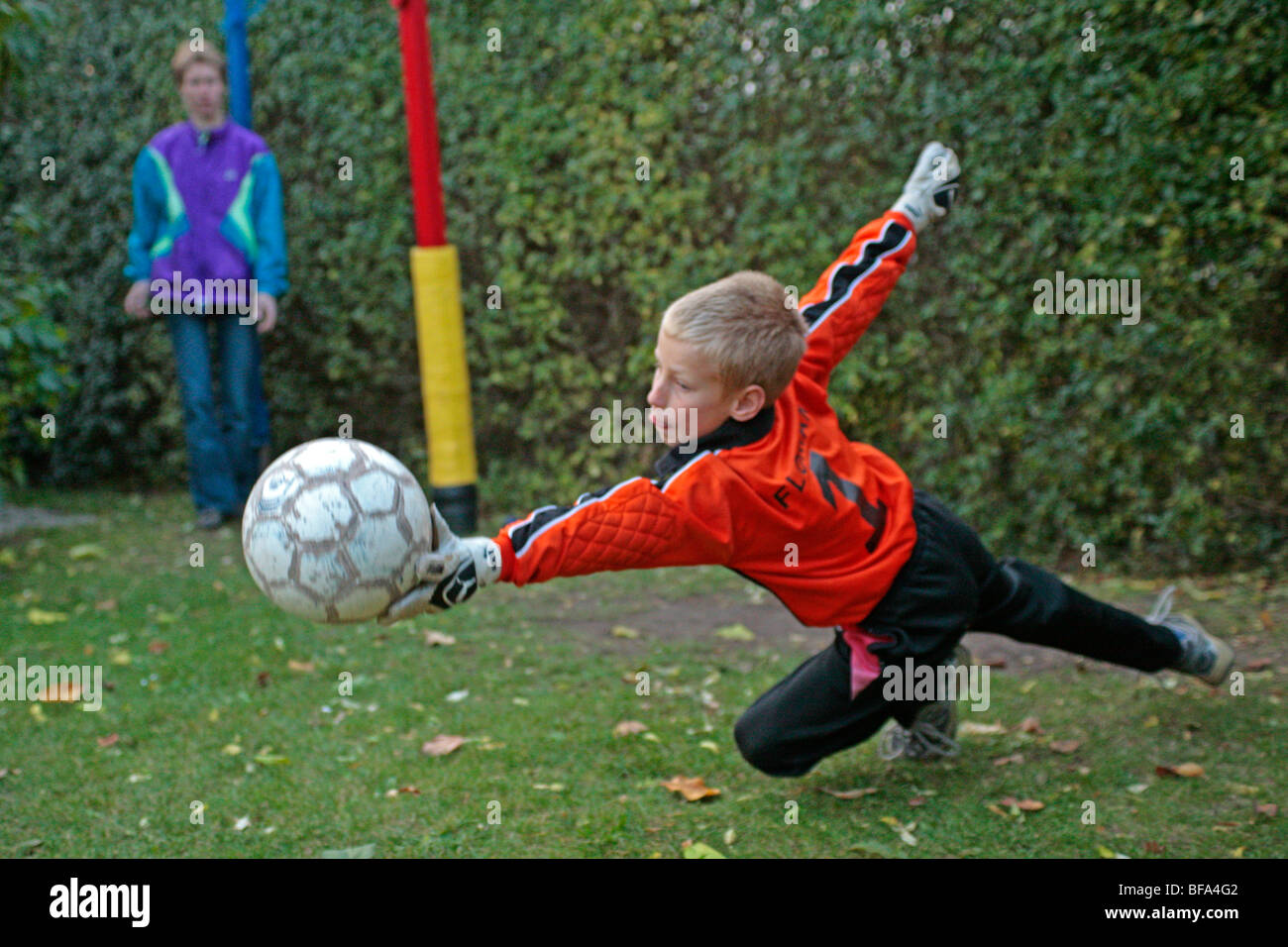 young boy catching a football his mother has kicked Stock Photo - Alamy