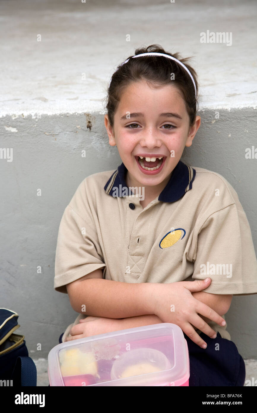 Schoolgirl laughing with lunch box on her lap Stock Photo - Alamy